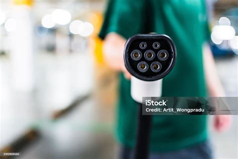 주차장에서 사람이 들고 있는 전기차 충전 플러그를 클로즈업한 사진으로 지속 가능한 교통과 기술을 강조합니다 교통수단에 대한 스톡 사진 및 기타 이미지 Istock