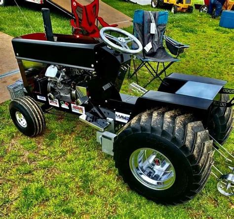 Lawn Mower Tractor Pulling On Lush Green Field