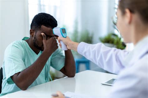 병원이나 진료소 내에서 환자에게 환자의 체온 검사를 확인하는 의사 온도 남자 사람 의사 체온 검사 및 진료소에서의 건강 검진