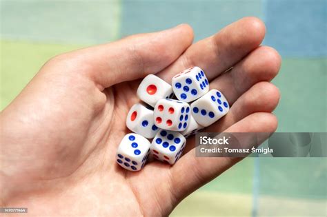 손에 다른 숫자를 보여주는 몇 개의 작은 게임 주사위를 들고 있는 남자 물체 그룹이 클로즈업됩니다 수학 무작위성 엔트로피 확률