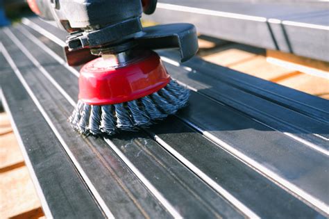 전기 분쇄기로 철을 연마합니다 금속 표면 와이어 클리닝 브러시에서 녹을 청소하기위한 와이어 브러시 페인팅 하기 전에 녹에서 금속