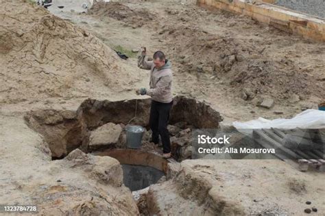 한 남자가 구덩이에 있는 우물에서 양동이에 물을 그립니다 관광객에 대한 스톡 사진 및 기타 이미지 관광객 남자 땅 Istock