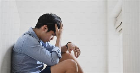 슬프고 우울한 남자의 초상화는 슬픈 기분으로 콘도미니엄이나 사무실의 산책로에 앉아 피곤하고 외롭고 불행하다고 느낍니다 사진