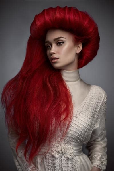 پرتره زن زیبای مو قرمز با لباس قدیمی سفید که در پس زمینه خاکستری جلوی