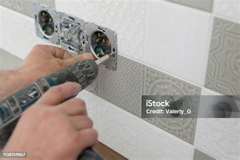 주방에서의 리노베이션 및 건설 전기 기술자의 클로즈업 전문 도구를 사용 하 여 세라믹 타일로 벽에 콘센트 설치 가정 생활에 대한 스톡 사진 및 기타 이미지 Istock