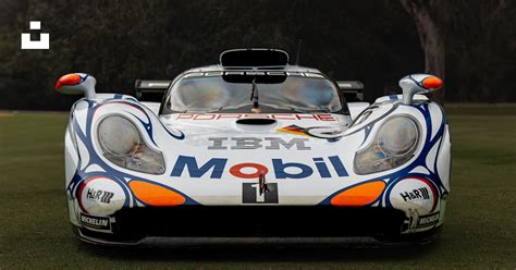 무성한 녹색 들판 위에 앉아있는 흰색과 주황색의 경주용 자동차 사진 Unsplash의 무료 올랜도 이미지