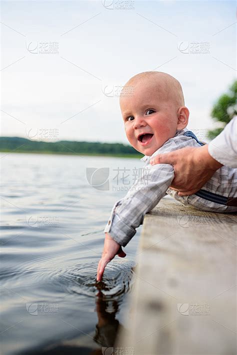 一个一岁的小男孩伸手去抓水。