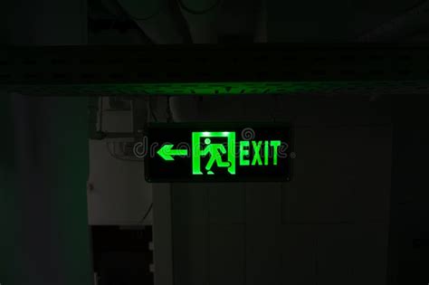 Green Exit Sign Illuminated In The Darkness Of A Room Stock Image Image Of Room Wires