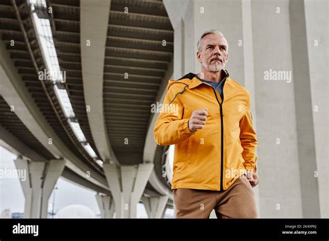 Graphic Waist Up Portrait Of Handsome Mature Man Running Towards Camera In Urban City Setting