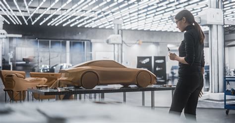 젊은 자동차 아티스트가 최신 콘셉트카 제작에 마지막 작업을 하는 모습 프로토타입 작업을 하는 여성 디자이너 스포츠 쿠페의 산업용 플라스틱 점토 3d 모델 조각 3차원 형태에