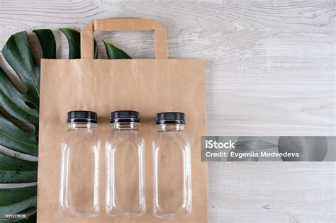 갈색 종이 에코 백에 3 개의 플라스틱 병 로고를 위한 장소 복사 공간이 있는 회색 배경에 친환경 식품 포장 및 면 에코 백 케이터링 및 길거리 패스트푸드용 용기 가방에