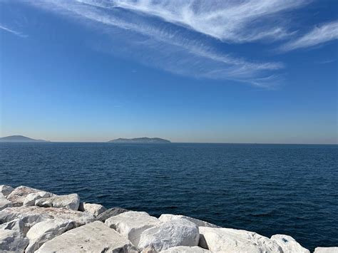 멀리 섬이 보이는 고요한 바다 전망 · 무료 스톡 사진