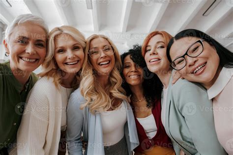 Low Angle View Of Multi Ethnic Group Of Mature Women Embracing And