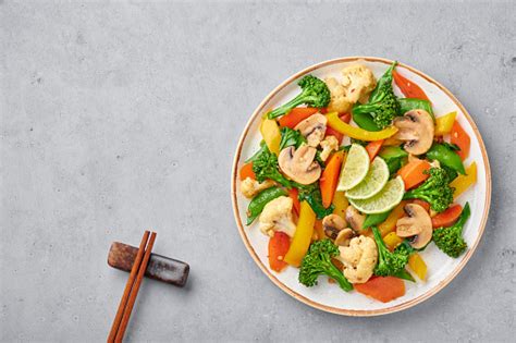 패드 박 루암 또는 회색 콘크리트 배경에 흰색 접시에 채식 볶음 야채 패드 팍 은 야채와 소스가 섞인 태국 요리 채식 요리입니다 태국 음식 공간을 복사합니다 맨 위 보기 0