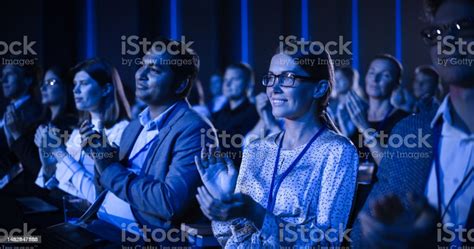 비즈니스 컨퍼런스에서 붐비는 청중에 앉아있는 젊은 여성 여성 참석자 응원과 박수 동기 부여 기조 연설 후 젊은 성공적인 사업가들과 함께하는 강당 청중에 대한 스톡 사진 및