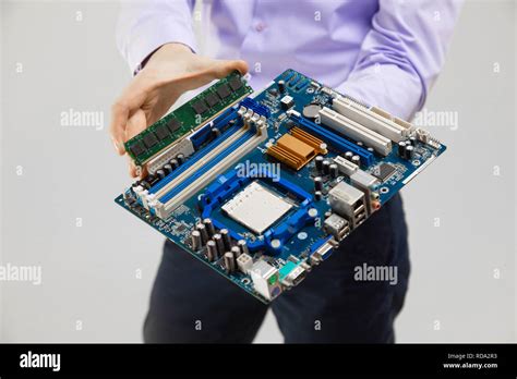 Ram And Motherboard In Men S Hands Close Up Isolated On Light Background Stock Photo Alamy