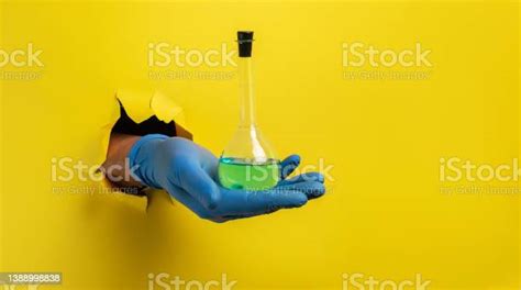 노란 종이에 찢어진 구멍을 통해 화학 플라스크를 들고 장갑 손 유전 연구 및 생명 공학 개념 과학자에 대한 스톡 사진 및 기타 이미지 Istock