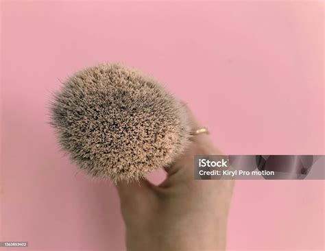 분홍색 배경에 파우더로 브러쉬 메이크업 아티스트의 손에 브러시 미네랄과 매트 베이지 파우더가 브러시에 적용됩니다 작업 할 준비가 된 천연 칫솔 가루로 빻은에 대한 스톡 사진