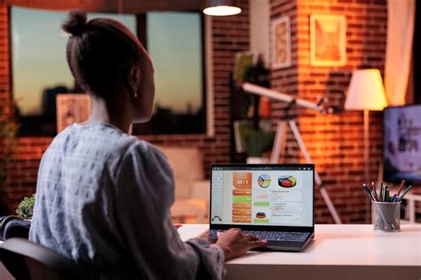 Деловая женщина смотрит на статистику маркетинговых исследований компании на экране ноутбука