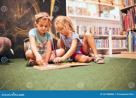 Two Elementary Schoolgirls Solving Puzzles And Riddles In School