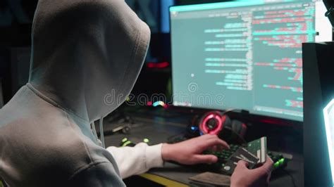 A Masked Hacker Breaks Into A Database On A Computer Hacking In A Dark