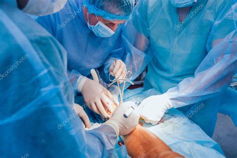 Proceso de cirugía de trauma. Grupo de cirujanos en quirófano con equipo quirúrgico. Formación ...