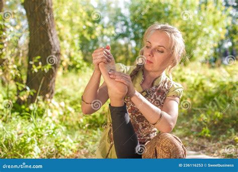 Two Women Massage Each Other On The Grass Of The Forest Stock Image