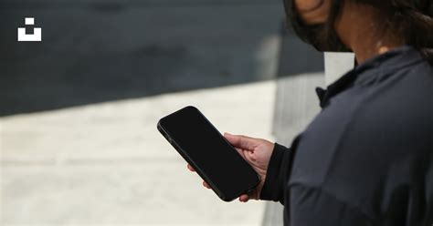 검은 드레스 셔츠를 입은 남자가 검은 스마트폰을 들고 있다 사진 Unsplash의 무료 추상적인 이미지