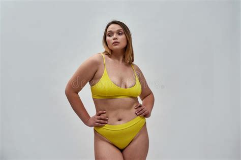 Curvy Young Female Model Wearing Yellow Underwear Looking at Camera while Posing Isolated Over ...