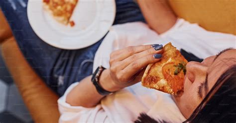 어린 갈색 머리는 피자와 스마트폰을 손에 들고 실내에 앉아 있다 사진 Unsplash의 우크라이나 이미지