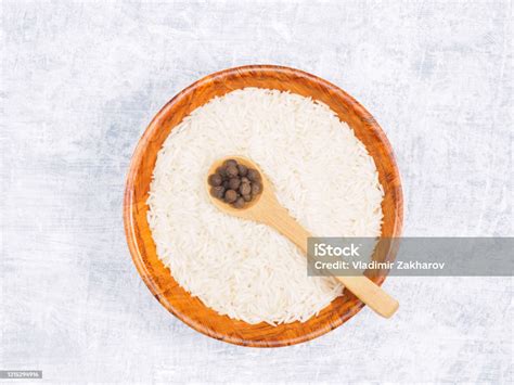 갈색 나무 그릇에 인도 긴 곡물 바스 마티 쌀과 흰색 콘크리트 배경에 숟가락에 올스파이스 0명에 대한 스톡 사진 및 기타 이미지