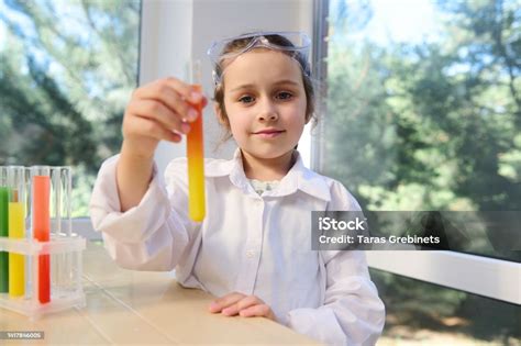 화학 수업에서 화학 반응이있는 시험관을 보여주는 흰색 실험실 코트의 아름다운 여학생 Stem 주제에 대한 스톡 사진 및 기타 이미지 Stem 주제 검사 보기 과학