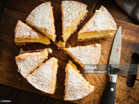 위에서 전체 빅토리아 스폰지 케이크는 어두운 나무 도마에 대한 거친 부분으로 슬라이스 0명에 대한 스톡 사진 및 기타 이미지