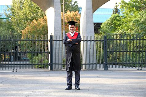 Man In Graduation Cap And Gown Stands Proudly Photo Free Education