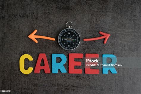 다채로운 나무 알파벳 단어 경력 및 자석 화살표가 왼쪽 및 오른쪽에 어두운 검은 칠판 시멘트 벽을 가리키는 나침반에 의해 회사 경력 경로 기회 개념 고용과 노동에 대한 스톡