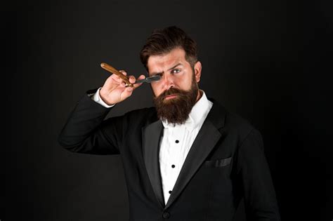 자기 관리는 이기적이지 않습니다 사업가는 면도기와 면도기의 면도기유지를 면도하지 않습니다 수염을 기리는 남자가 날카로운 칼날을 쥐고 있다 수염 스킨 케어 스킨케어 남성 스킨