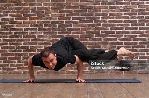 발랄 한 매력적인 젊은 남자 운동 요가 필 라 테 스 휘트니스 교육 아사 나 뒤에서 Kaundiniasana 벽돌 벽 배경 위에 스튜디오 촬영 전체 길이 강사에 대한 스톡