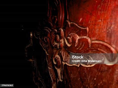 짙은 붉은 표면에 소용돌이치는 꽃무늬 디자인이 있는 복잡한 나무 조각 이 사진은 전통 목공의 예술성과 장인 정신을 강조합니다 갈색에 대한 스톡 사진 및 기타 이미지 Istock