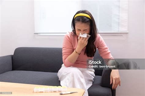 독감에 걸린 아시아 젊은 여성은 재채기를하고 냅킨을 사용하여 집에서 소파에 앉아 있습니다 부비동염에 대한 스톡 사진 및 기타 이미지 부비동염 약 25 29세 Istock