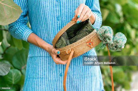 밖에 서 유행 세련 된 등나무 가방 실크 스카프와 여자 손 발리 인도네시아의 열 대 섬입니다 등나무 핸드백 및 실크 스카프