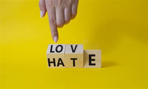Love Vs Hate Symbol Businessman Hand Points At Wooden Cubes With Words