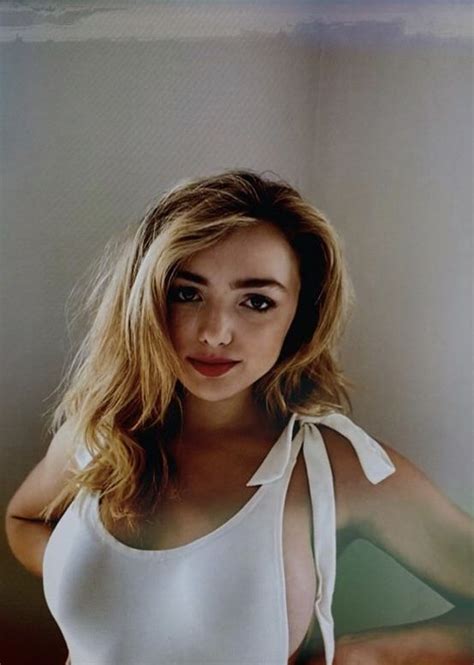 A Woman Posing For A Photo In A White Top