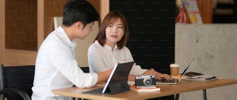 두 명의 사진작가가 공동 작업 공간에 앉아 디지털 장치와 카메라로 프로젝트에 대해 논의하는 장면 사진 Unsplash의 태국 이미지