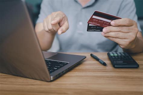A Man Hold Credit Card And Point To Monitor Laptop Computer In Hand