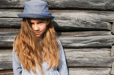 캐주얼 옷과 나무 벽에 의해 포즈 파란색 모자에 긴 머리를 가진 즐거운 십 대 소녀 활동적인 생활양식입니다 청소년 패션 감정에 대한 스톡 사진 및 기타 이미지 Istock