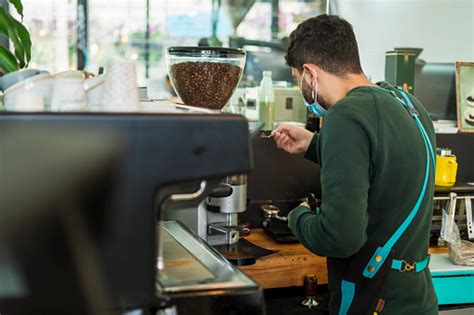 커피 공장의 라틴계 남성 직원이 고객을 위해 커피를 준비하는 바 안에 서 있습니다 기계류에 대한 스톡 사진 및 기타 이미지 기계류 기업 비즈니스 남자 Istock