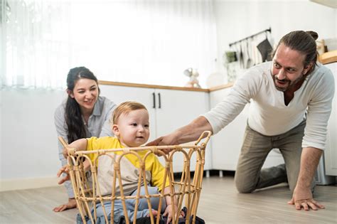 백인 을 사랑하는 부모는 바닥에 부엌에서 아기 유아와 함께 재생합니다 아름다운 부부 어머니와 아버지는 어린 어린 아들 아이와 놀고 유아를 바구니에 넣습니다 홈 컨셉의 활동