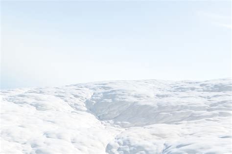 강하고 밝은 하늘에 있는 겨울 북극 풍경을 3d 렌더링했습니다 맑고 푸른 하늘과 햇빛이 있는 눈 서리 얼음의 변화하는 언덕 눈 언덕의 봉우리 겨울 배경입니다 가장자리의 로우