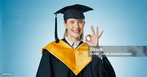 졸업 괜찮고 교육 학습 또는 대학 성취를 위해 스튜디오에서 성공한 학생 파란색 배경에 예 우수성 및 인증 또는 양호에 대한 손 또는 이모티콘을 가진 여성의 초상화 25 29