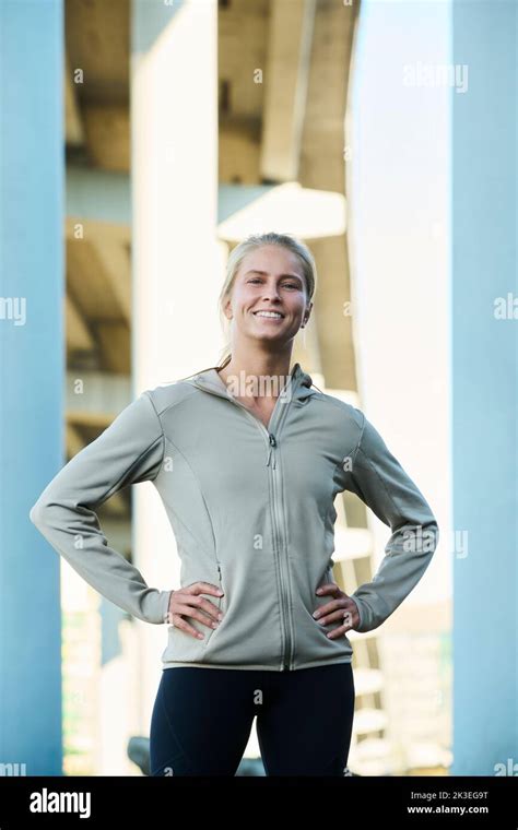 Happy Young Blond Female Athlete With Toothy Smile Keeping Hands On